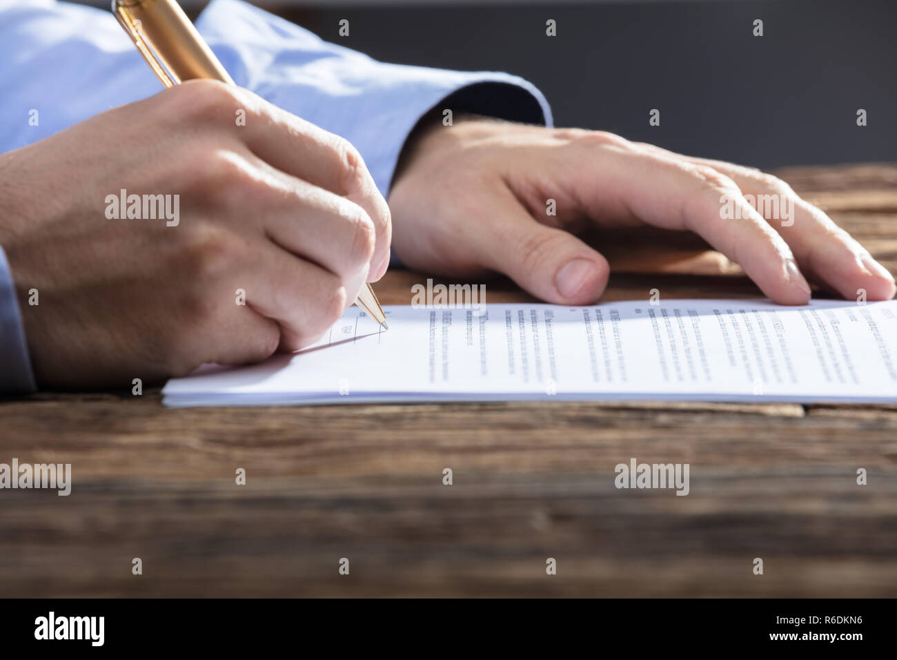 Businessperson's Hand Signing Document Stock Photo - Alamy