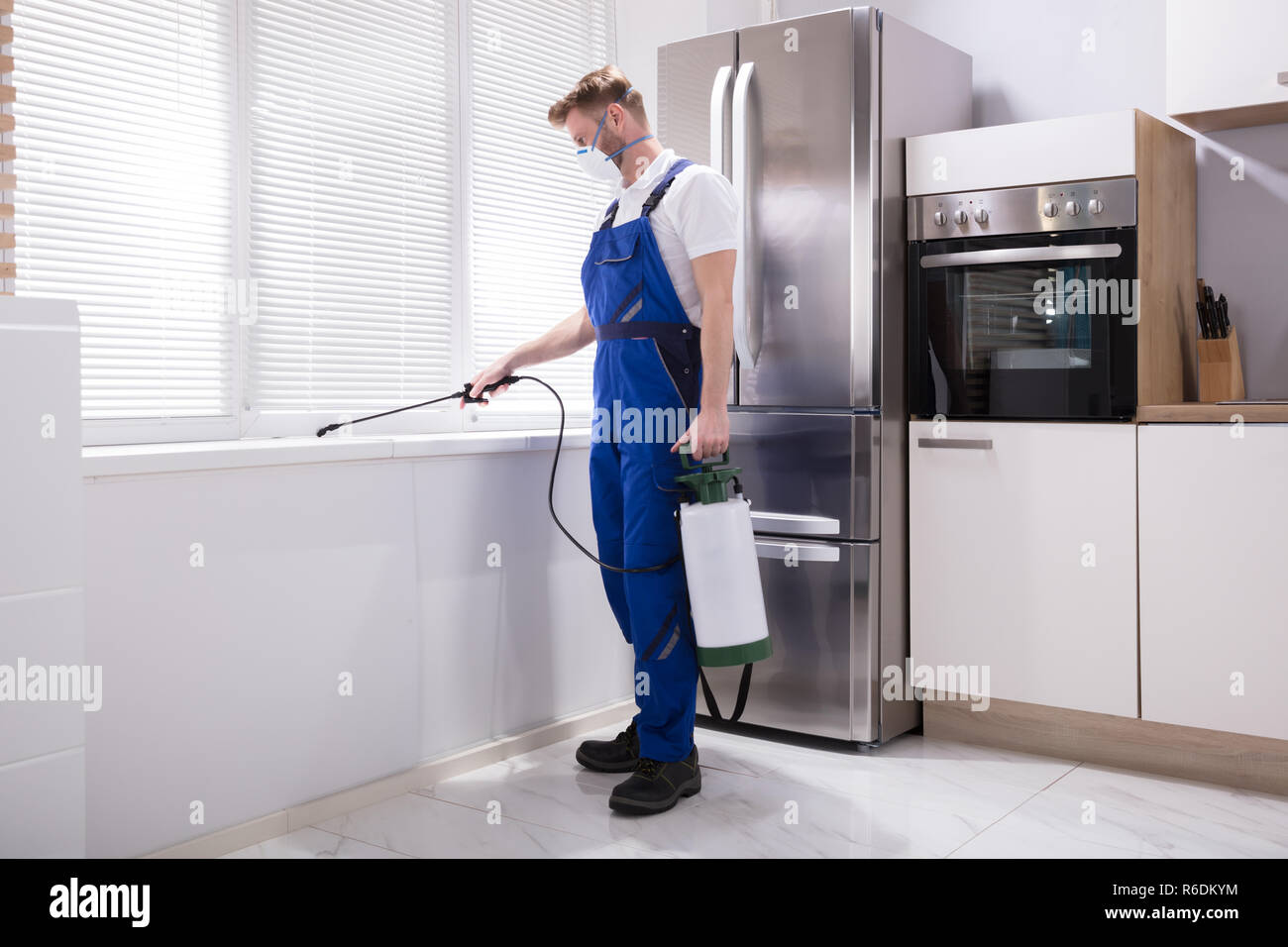 Exterminator Worker Spraying Insecticide Chemical Stock Photo - Alamy