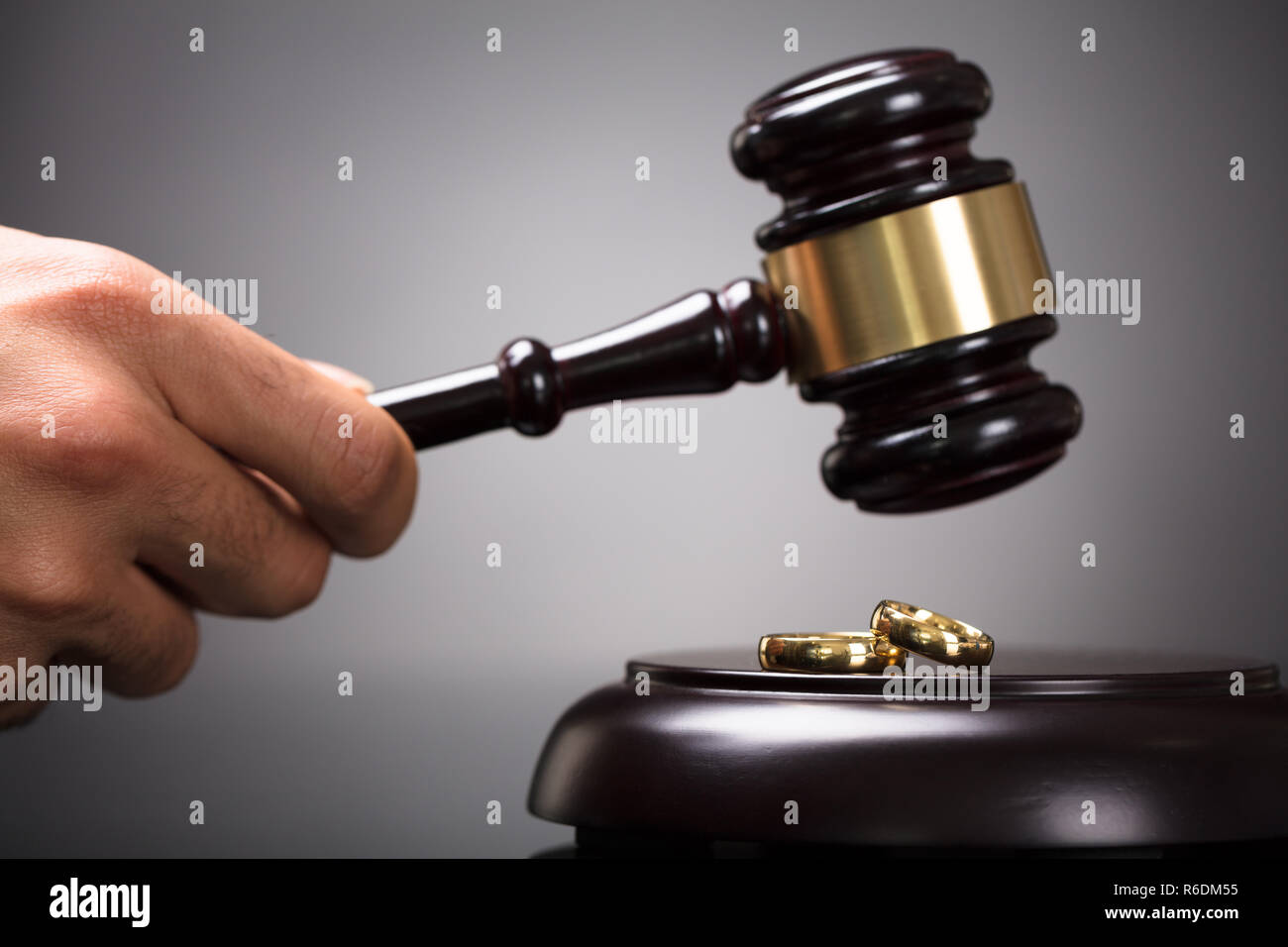 Judge Hitting Gavel On Golden Rings Stock Photo - Alamy