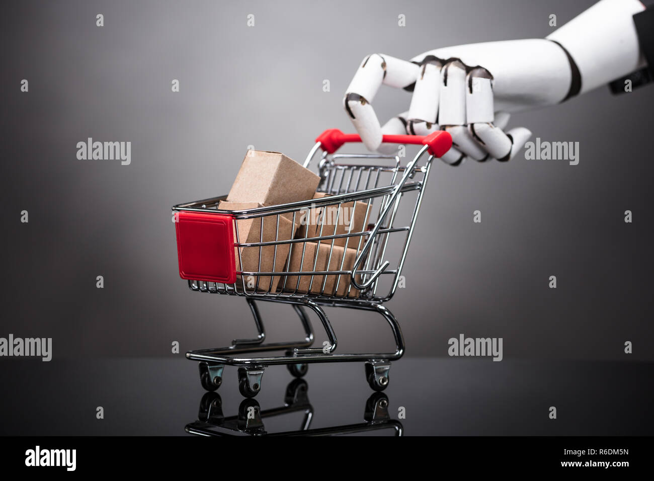 Robot Holding Shopping Cart With Cardboard Boxes Stock Photo - Alamy