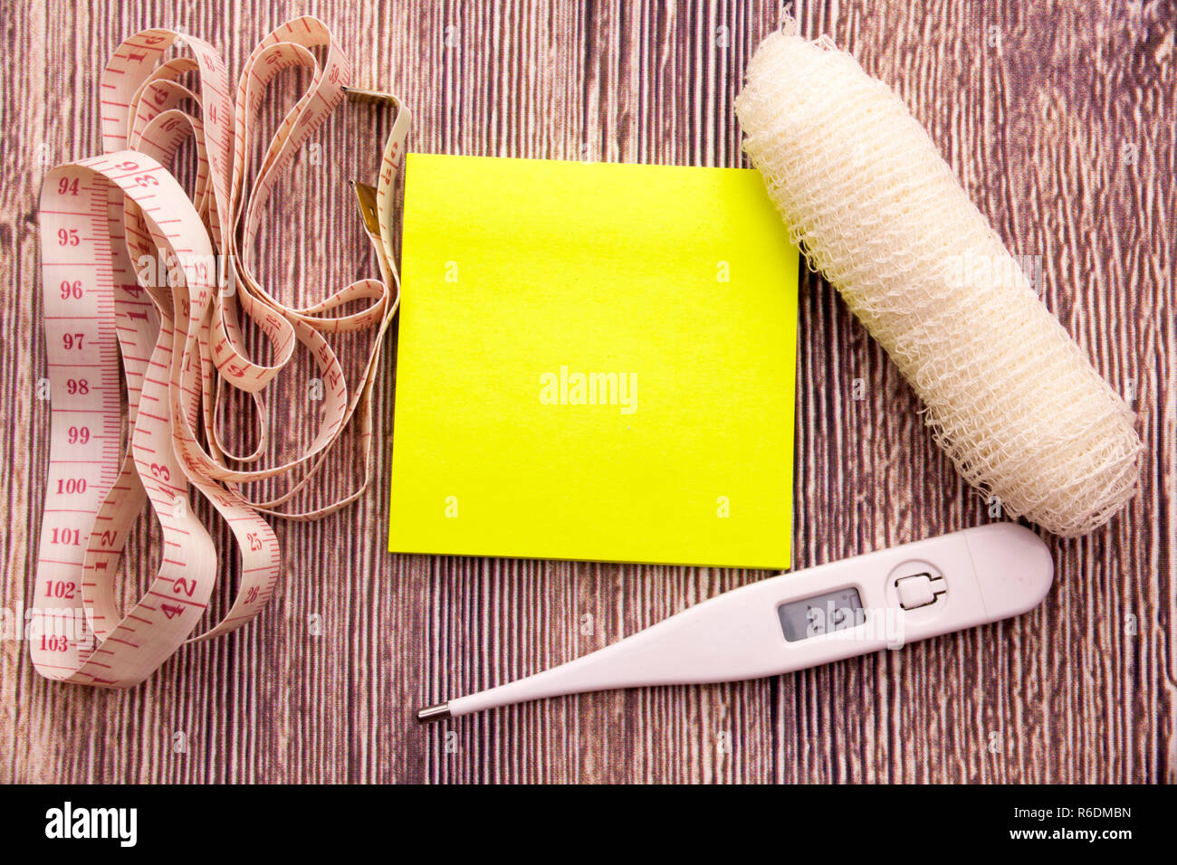 heart symbols and blank yellow sticky note on wooden background ...