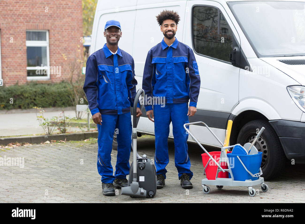 Portrait Of Two Happy Male Janitor Stock Photo - Alamy