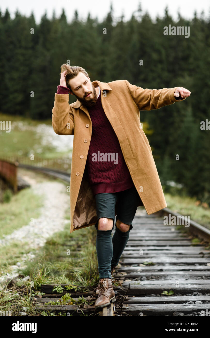 brutal bearded man walks on the tracks Stock Photo - Alamy