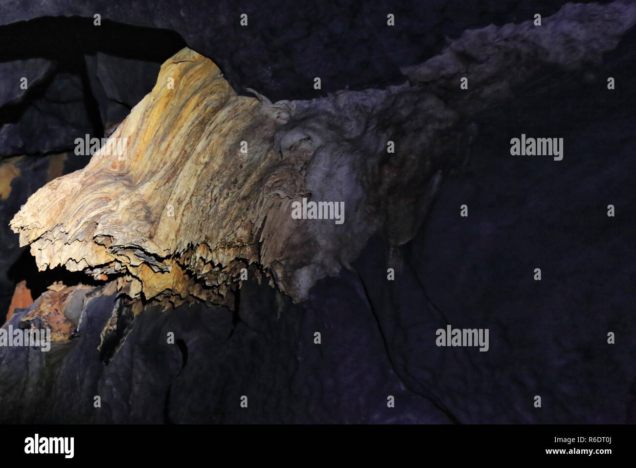 Rock formations of grey limestone with speleogens and reddish ...