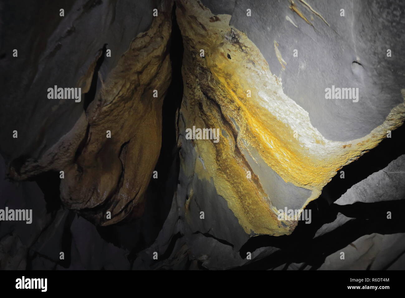 Rock formations of grey limestone with speleogens and reddish ...