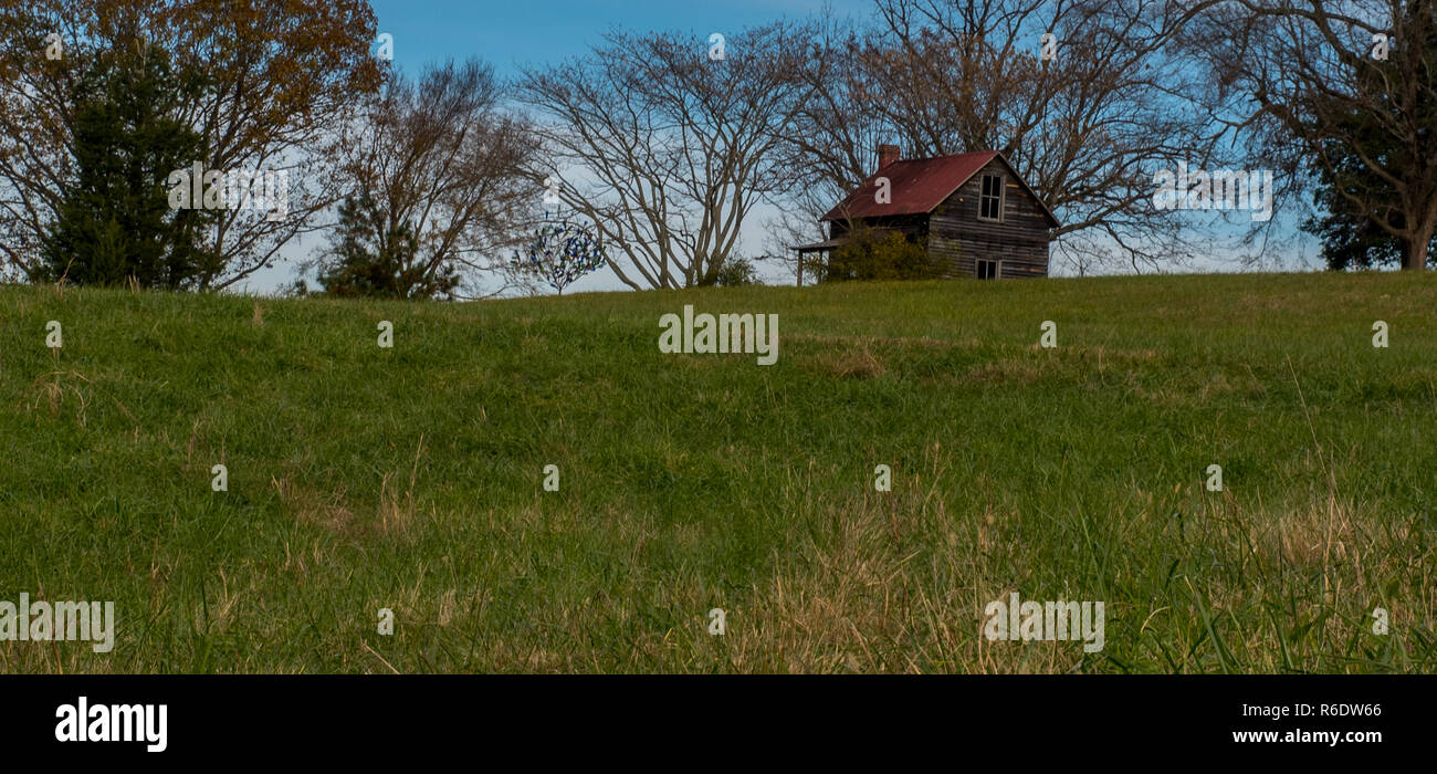 Old log cabin on hill under trees with sky in the background Stock ...