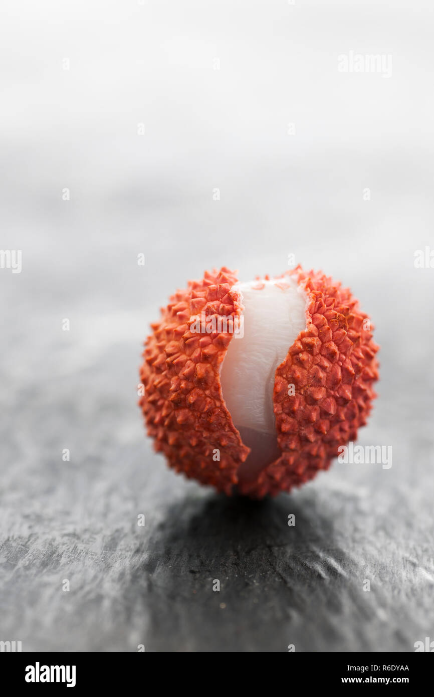 single lychee on slate Stock Photo - Alamy