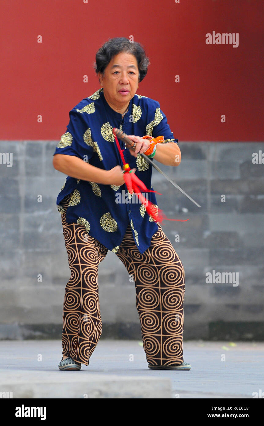 Old Lady Practices Traditional Gymnastics With A Sword In Jingshan Park ...