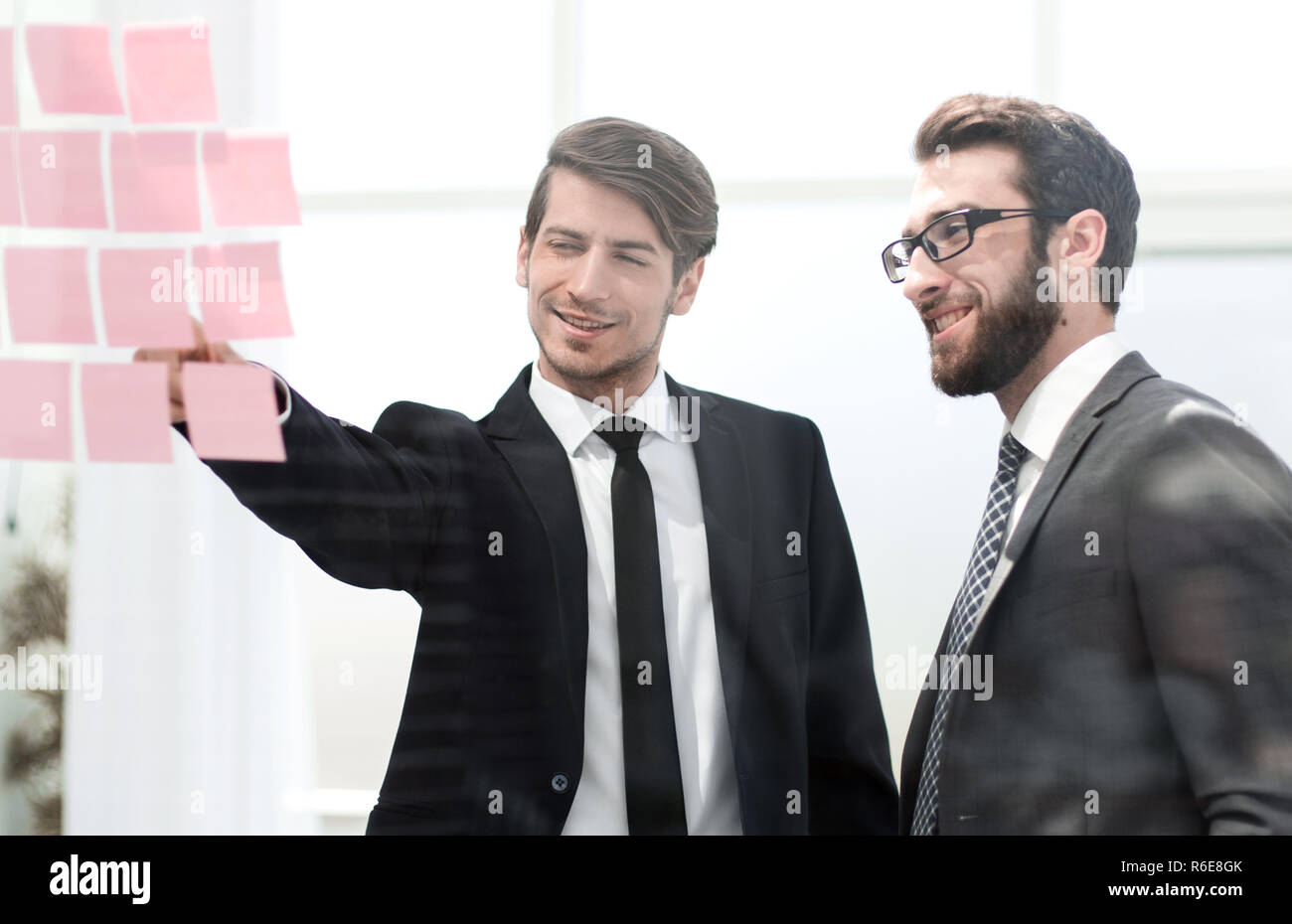 business colleagues discussing stickers-notes on the office Board Stock ...