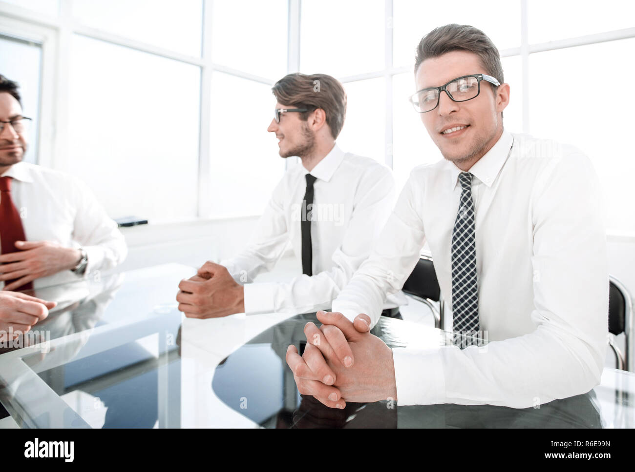 three professional employees sitting at the office table Stock Photo ...