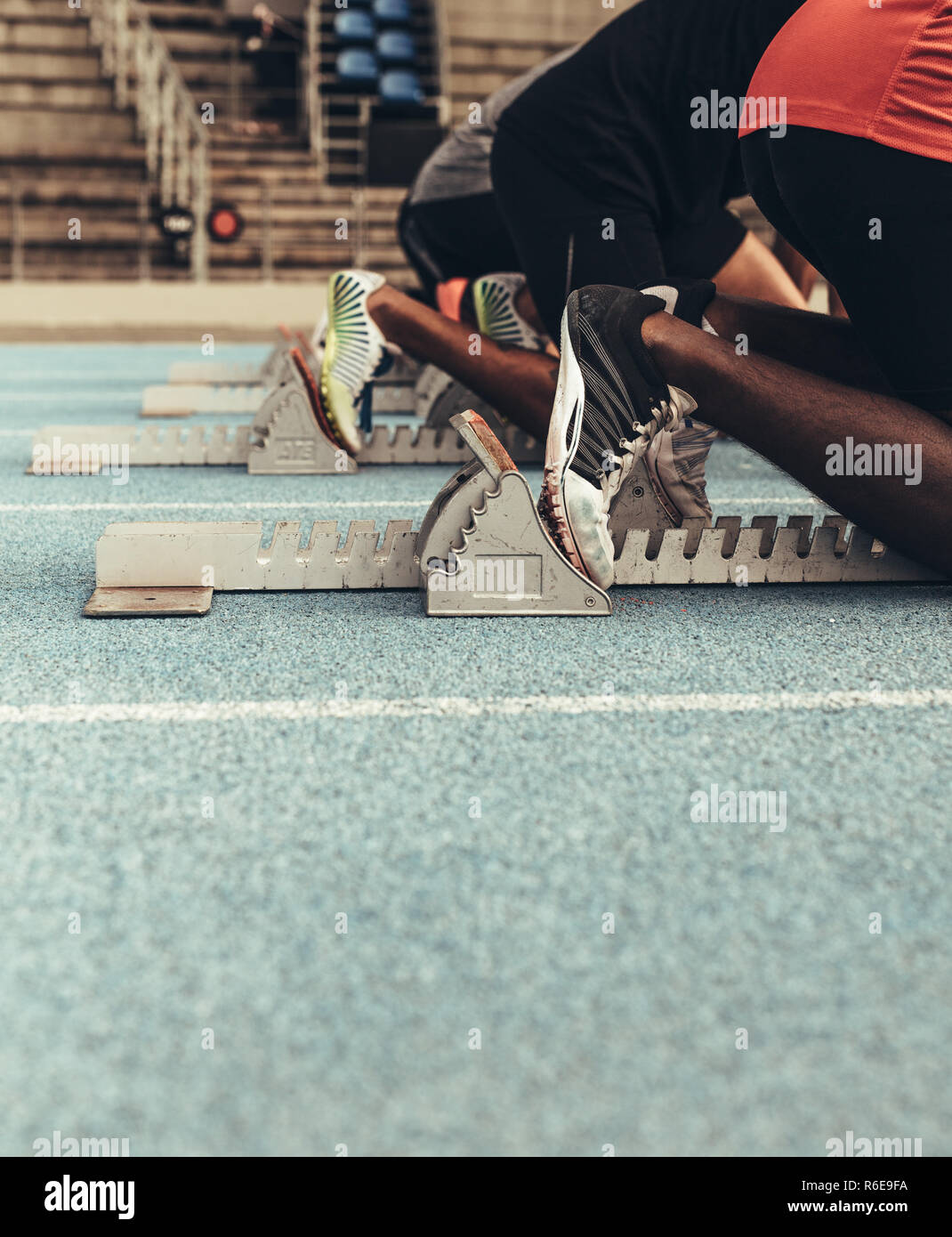 Sprinters on their mark ready to sprint on an all weather running track ...