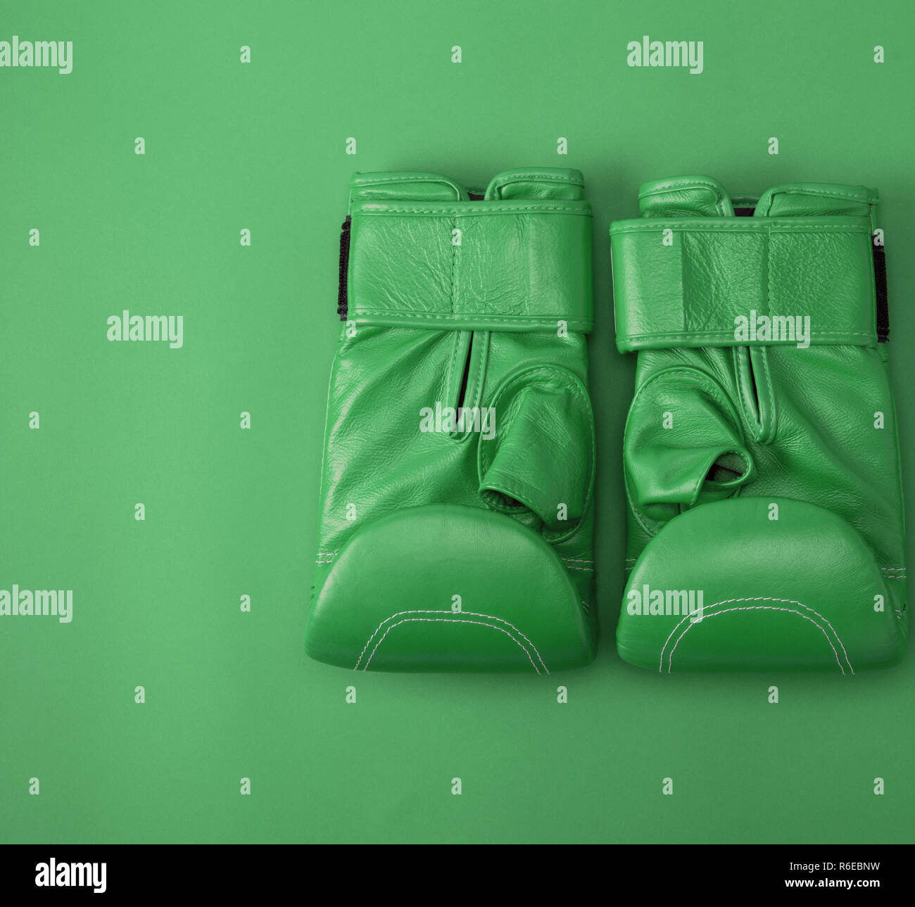 green sport leather boxing gloves on a green background, top view, copy ...