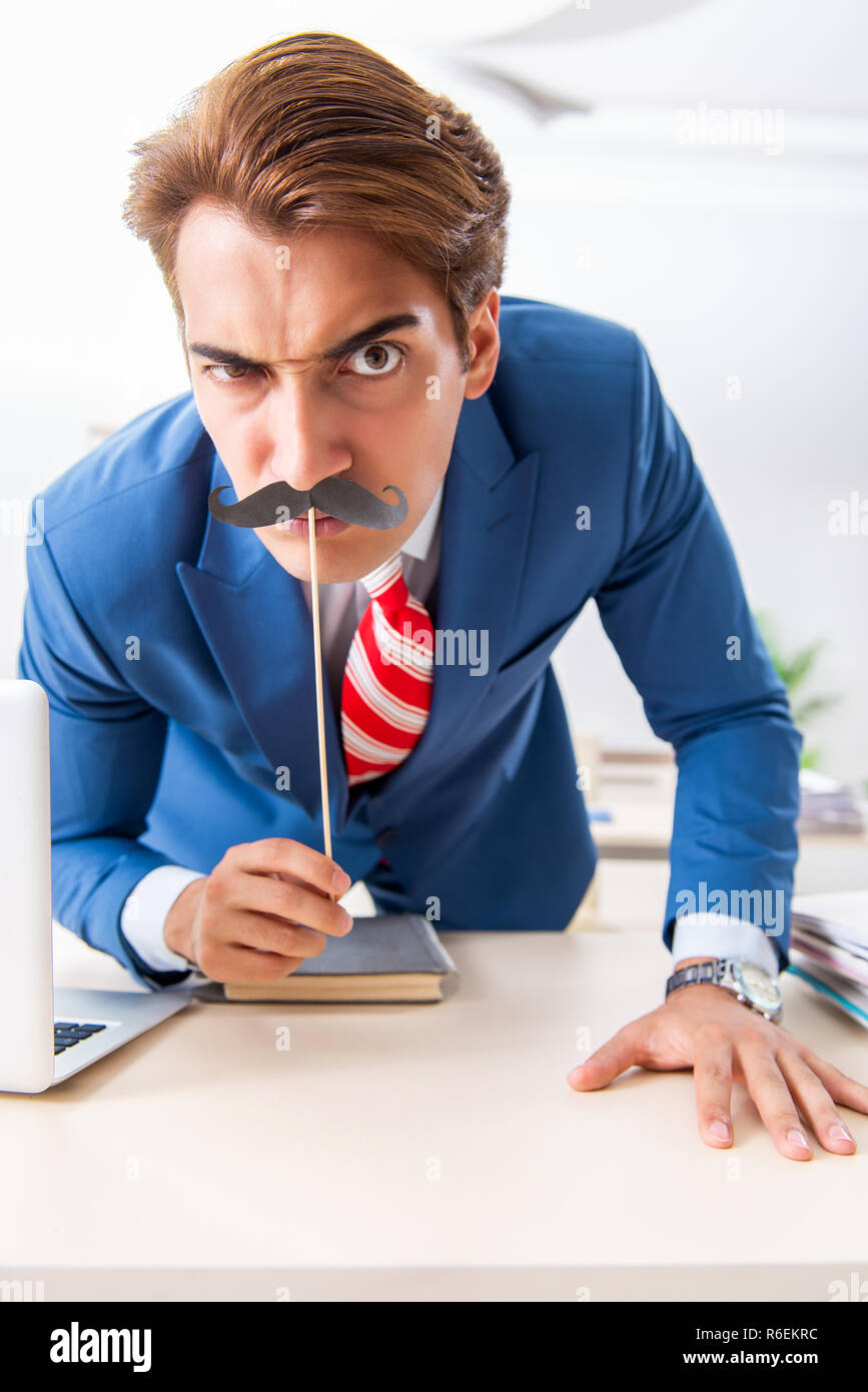 Funny bisinessman with fake moustache in the office Stock Photo - Alamy