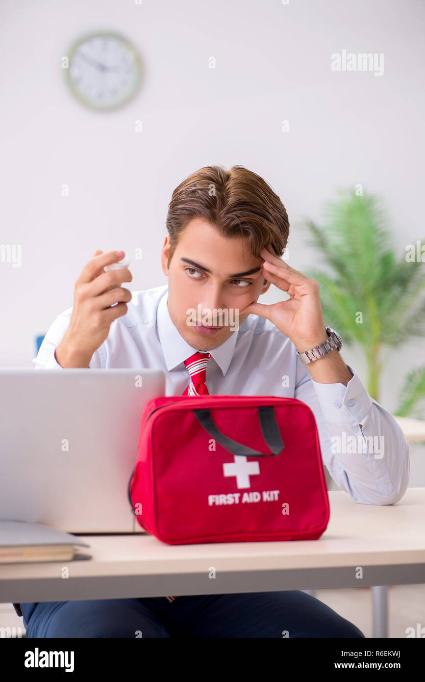 Man with first aid kit in the office Stock Photo - Alamy