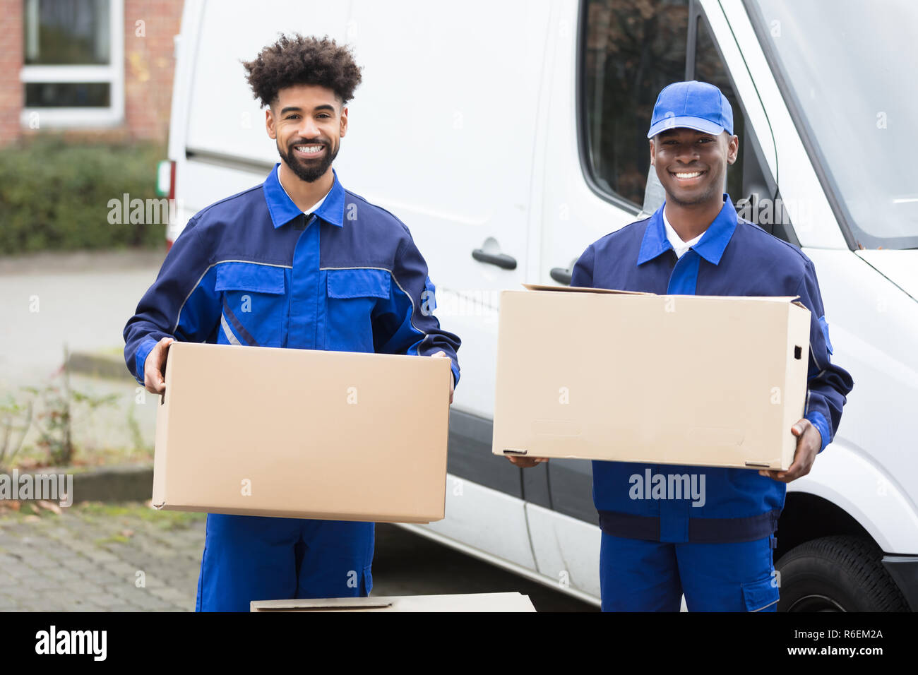 Two Men Holding The Cardboard Boxes Stock Photo - Alamy