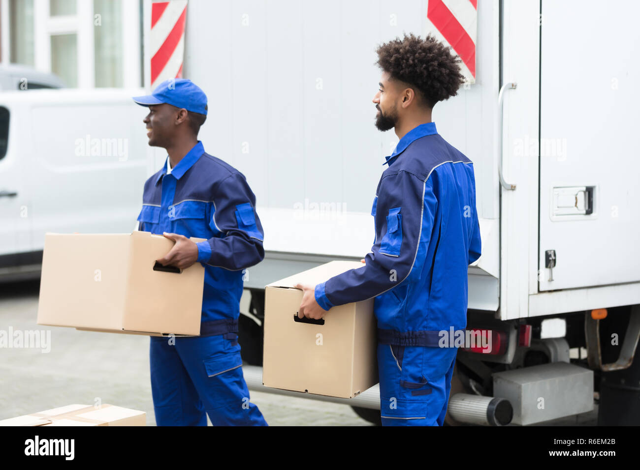 Two Men Holding The Cardboard Boxes Stock Photo - Alamy