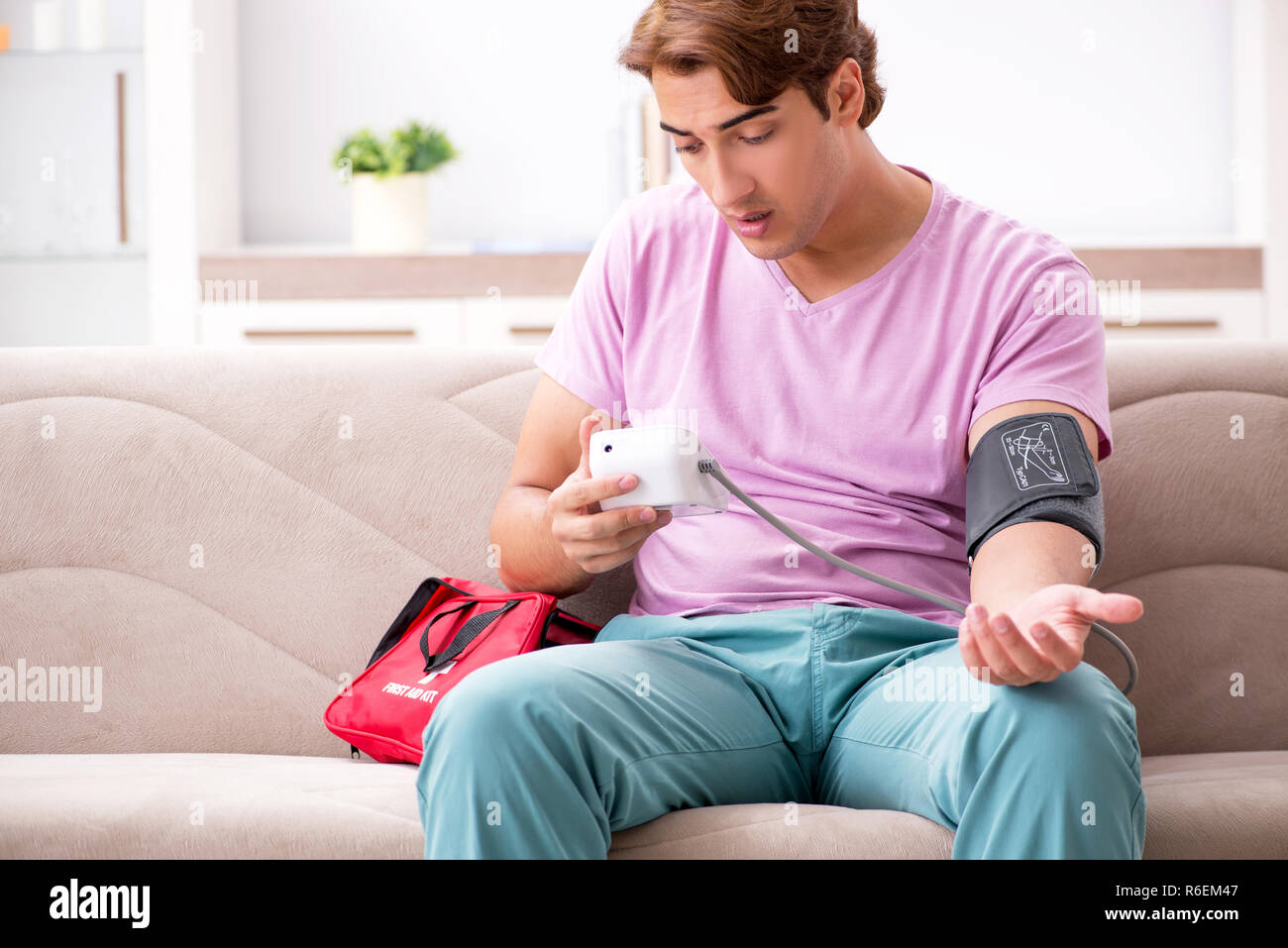 Sick man at home with first aid kit Stock Photo - Alamy