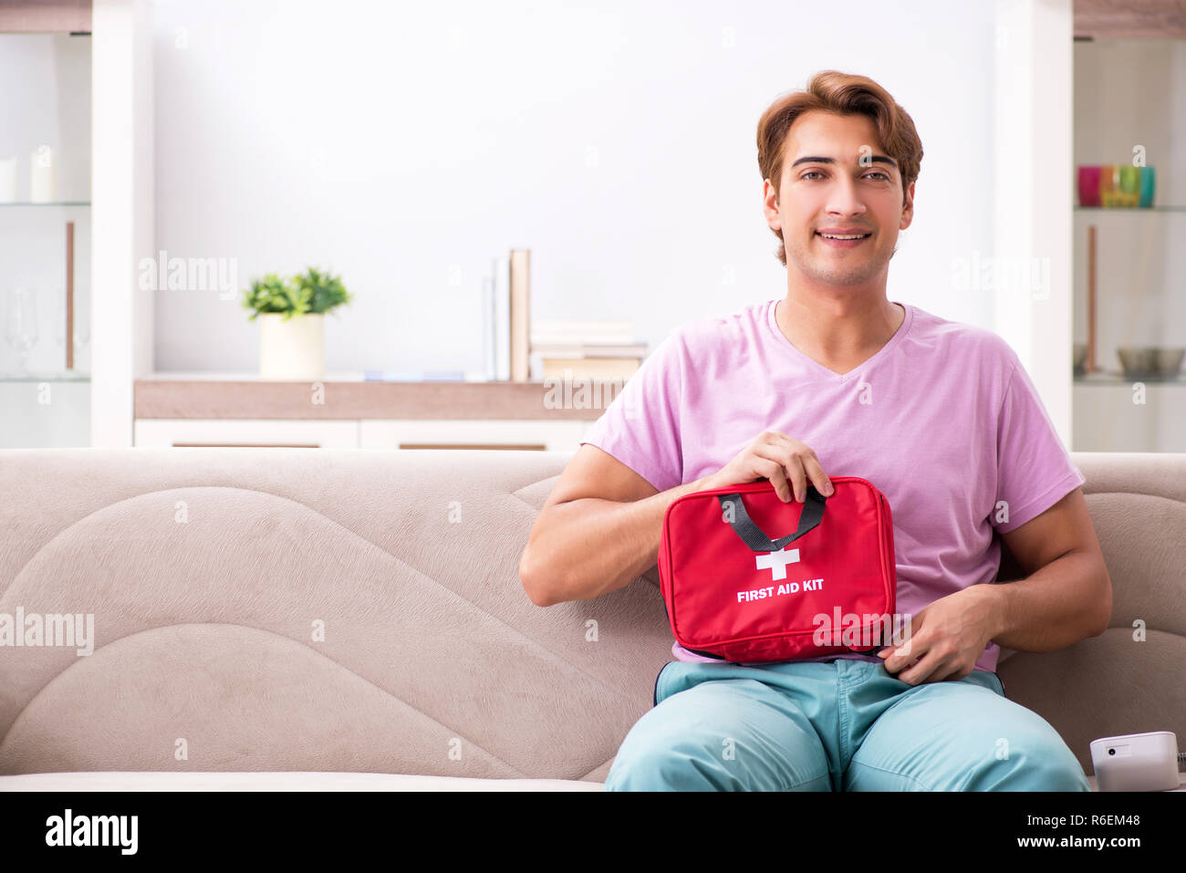 Sick man at home with first aid kit Stock Photo - Alamy