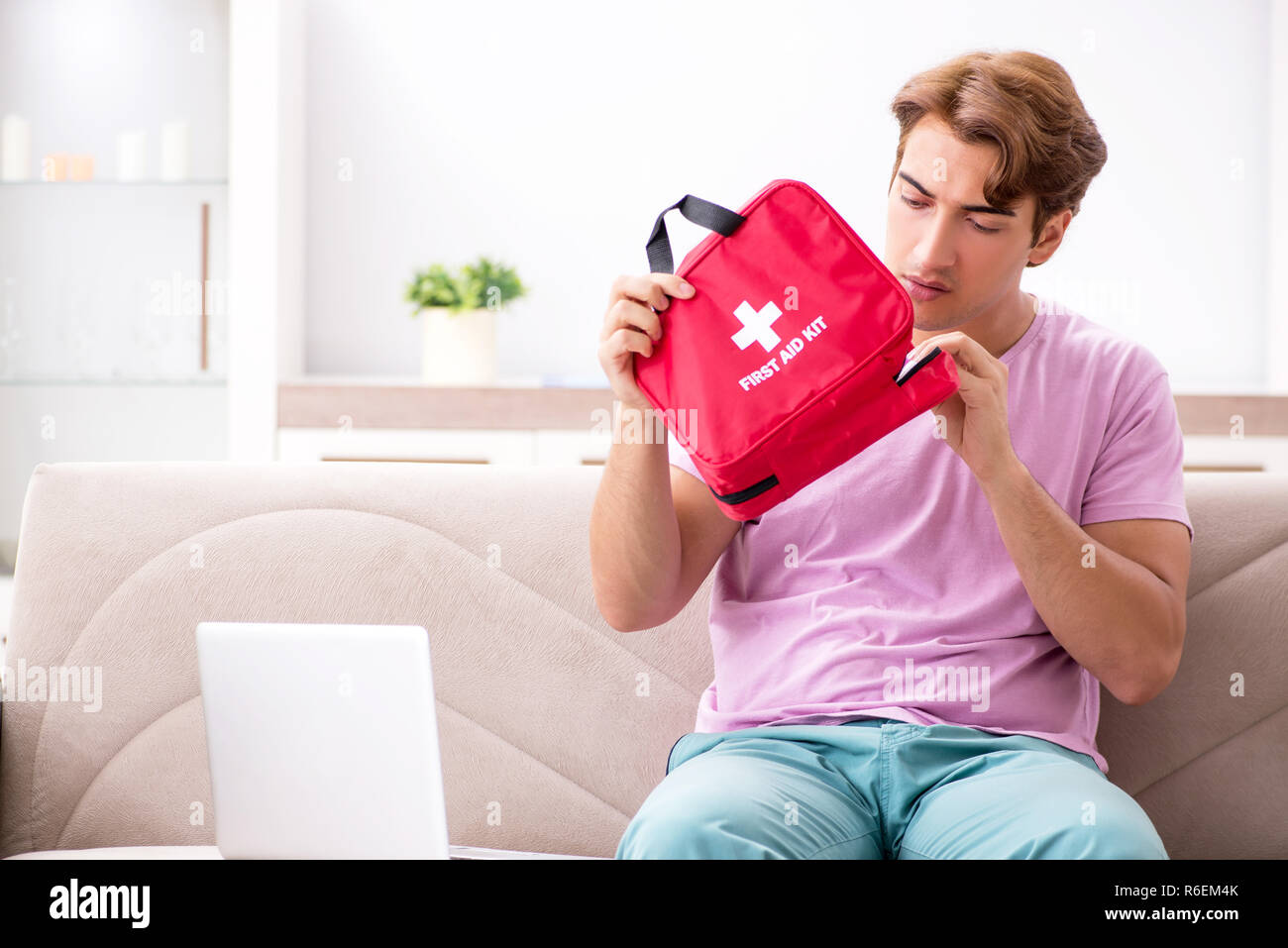 Sick man at home with first aid kit Stock Photo - Alamy