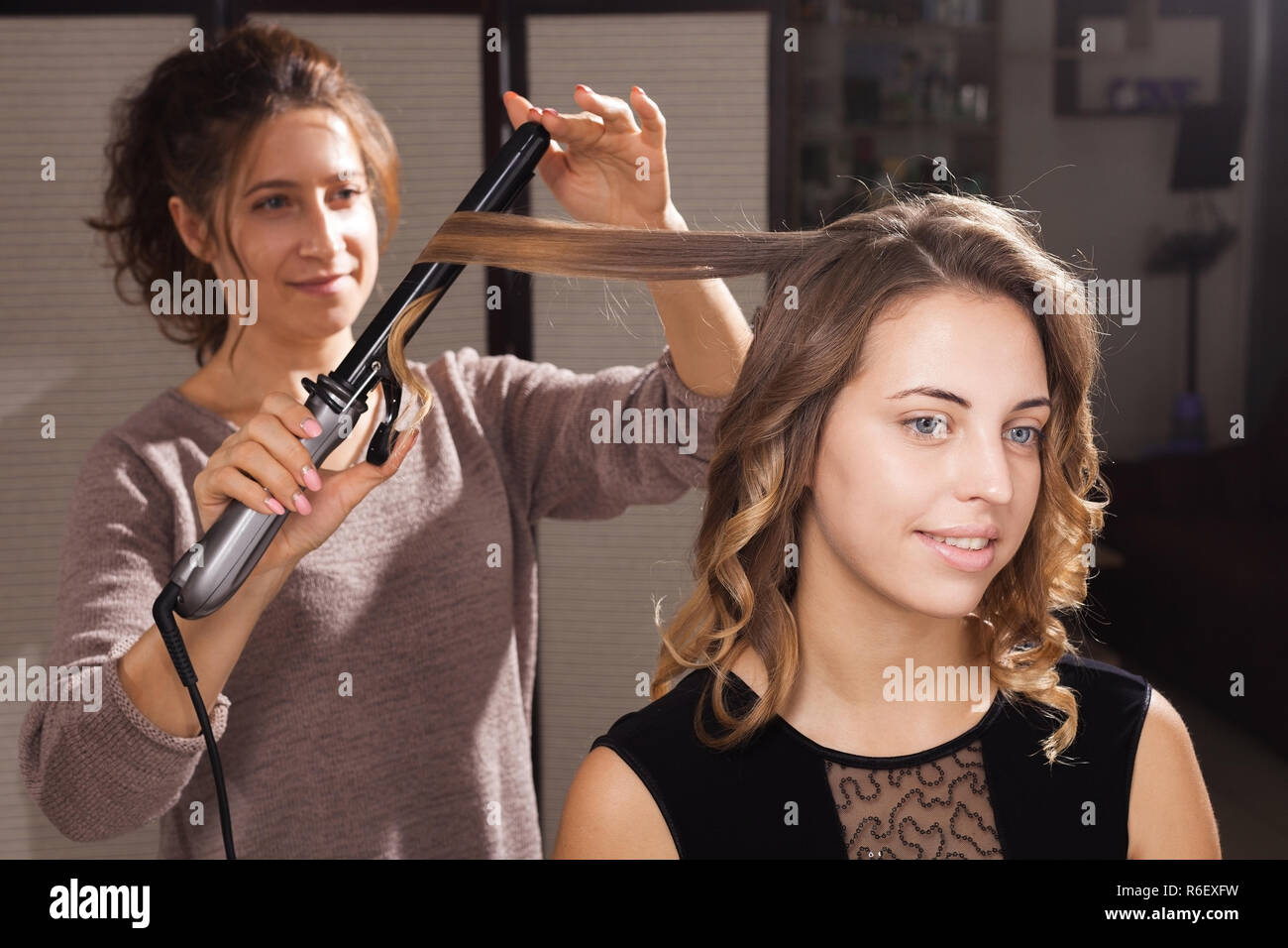 hairdresser making a hairdo with waves to a model Stock Photo - Alamy