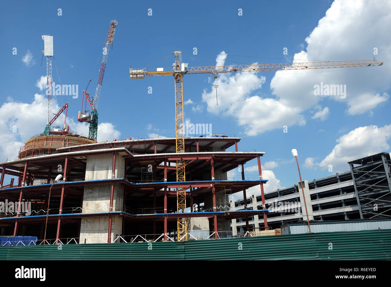 Tower cranes on industrial building construction over blue sky with ...