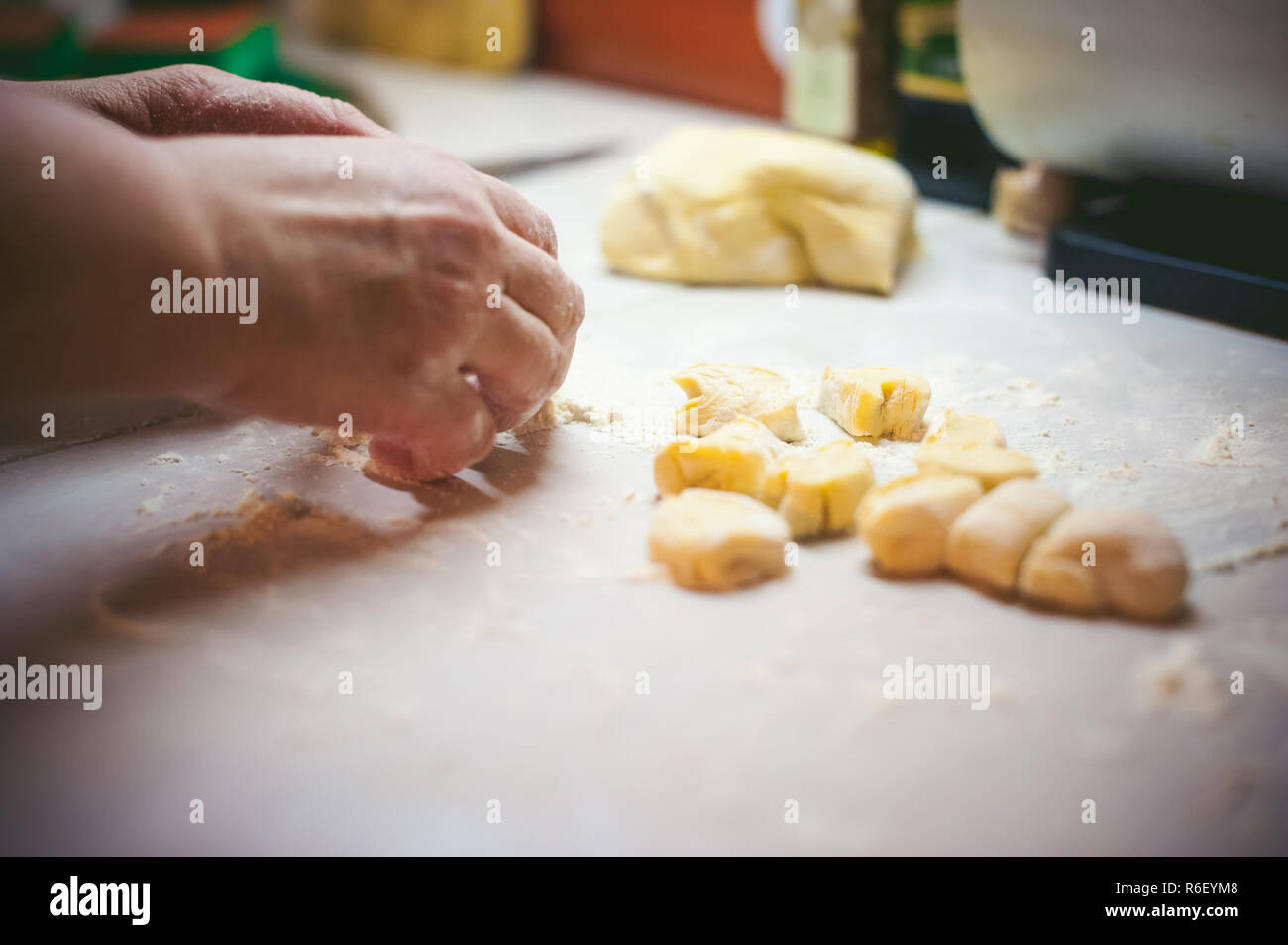 hand modeling dumplings at home in the kitchen. hands and the dough ...