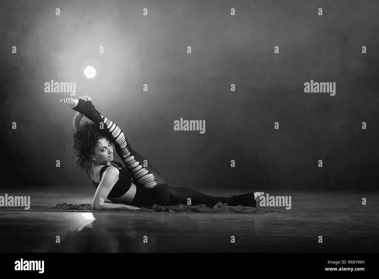 Young and fit woman performing a contemporary dance pose on a stage ...
