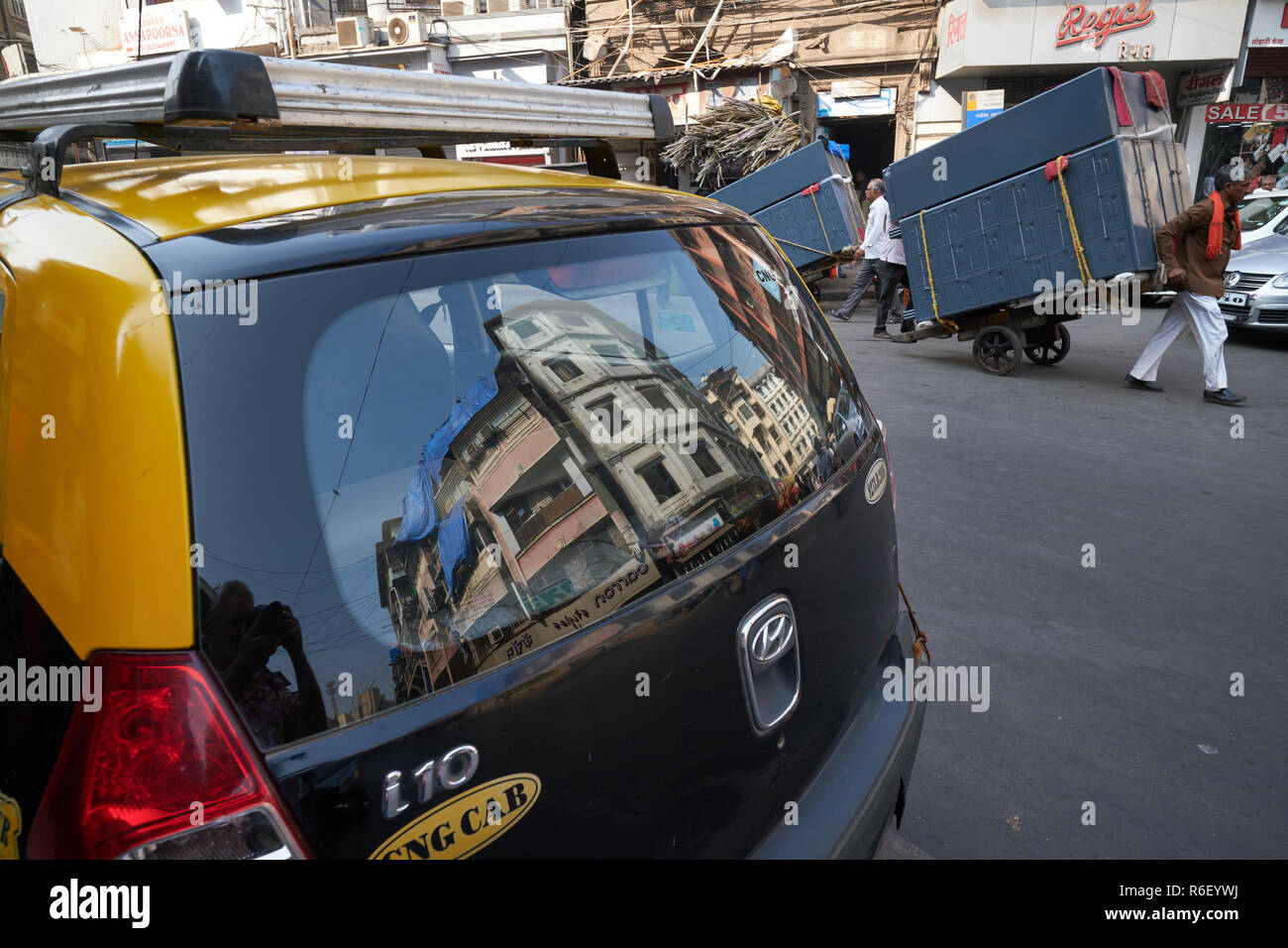 A taxi window in Kalbadevi business area in Mumbai, India, reflecting a ...