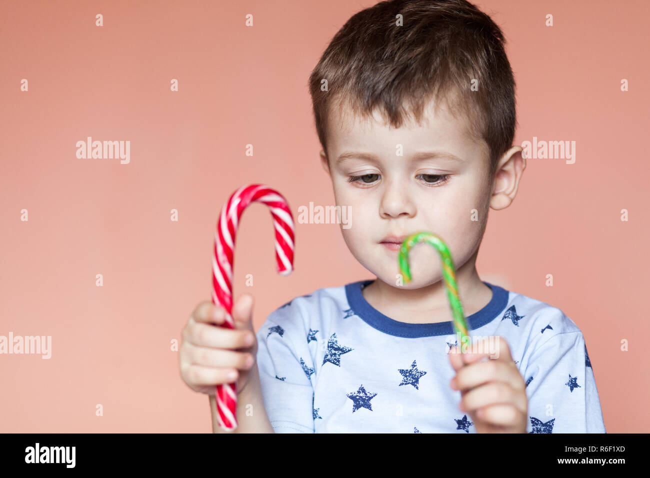 A cute boy holding two candy sticks Stock Photo - Alamy
