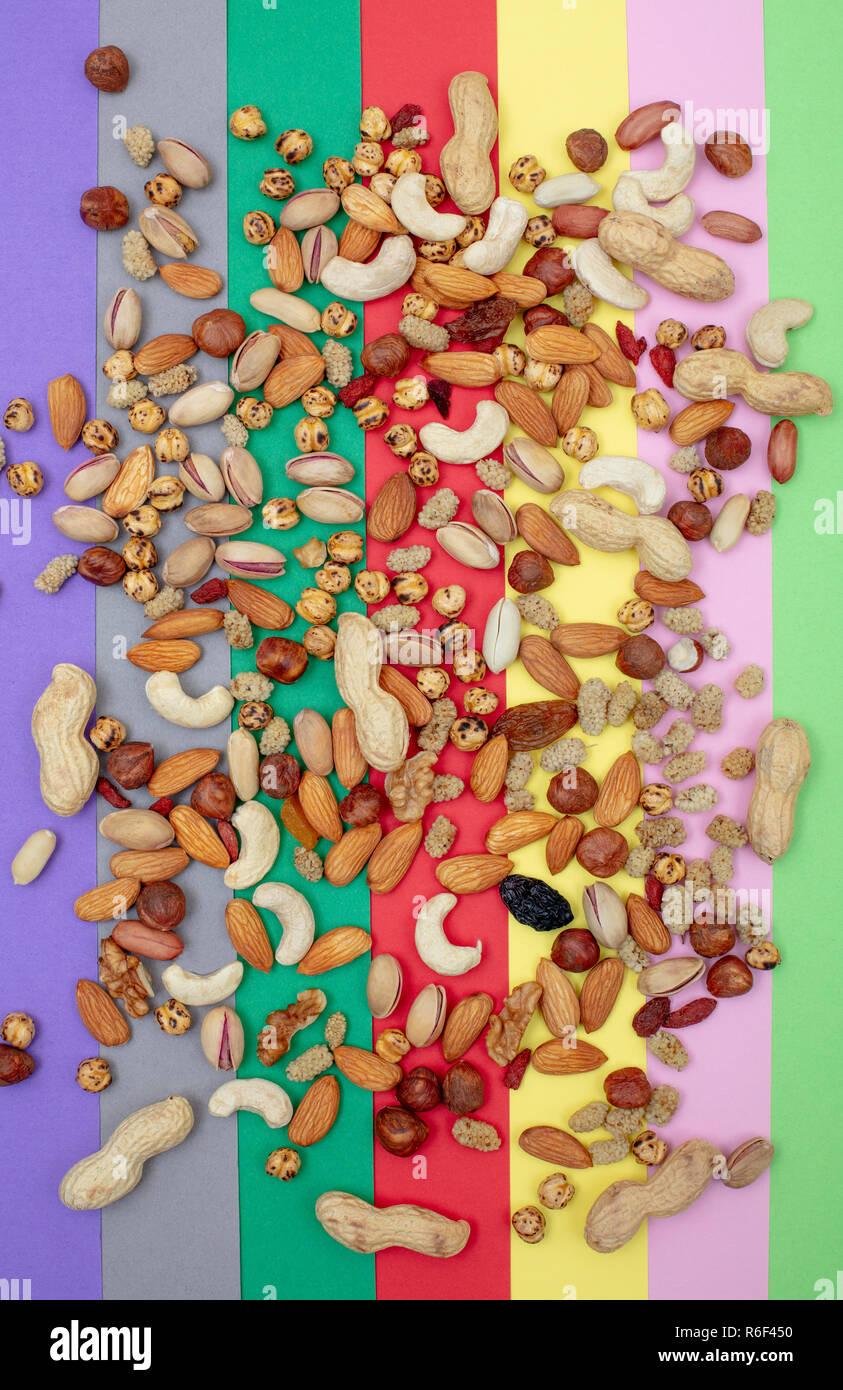 Assorted nuts scattered on a colorful paper background top view Stock ...