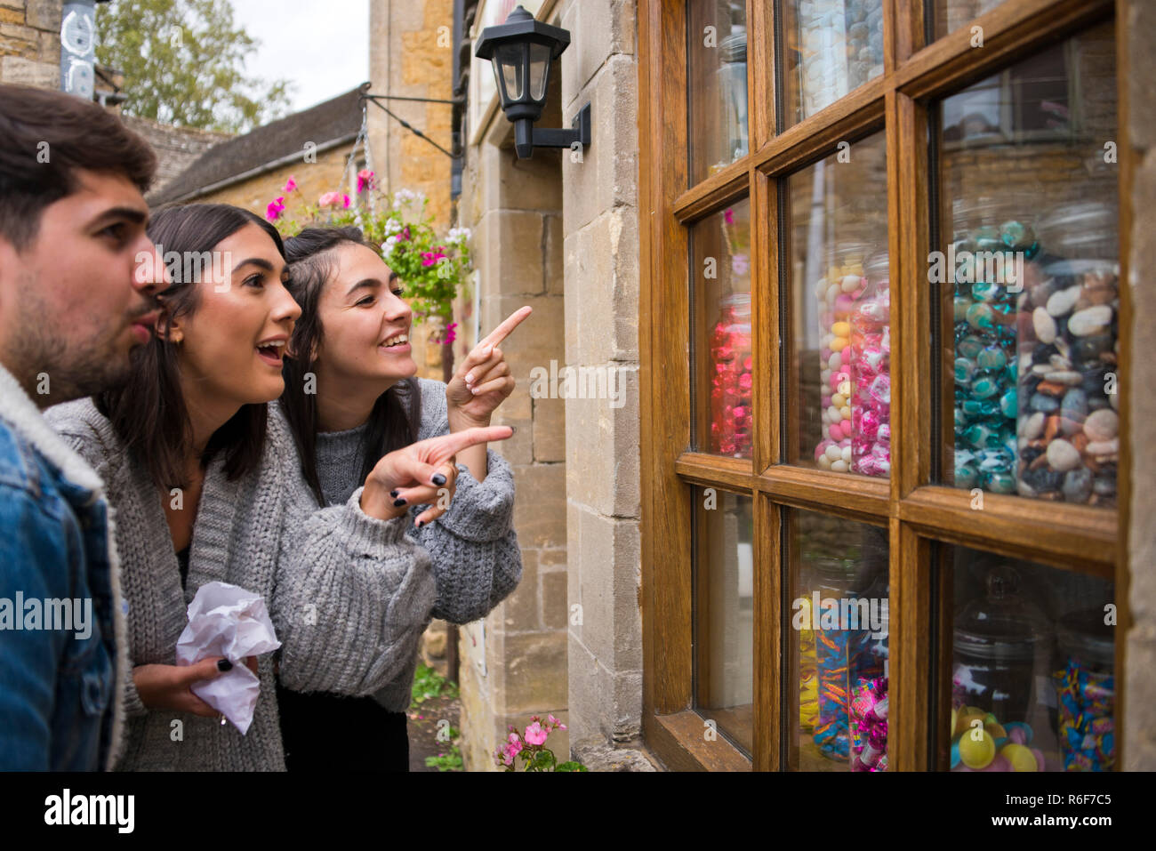 Horizontal portrait of young people looking into the window of a retro ...