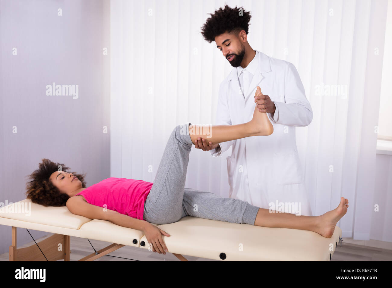 Physiotherapist Giving Leg Exercise To Patient Stock Photo - Alamy