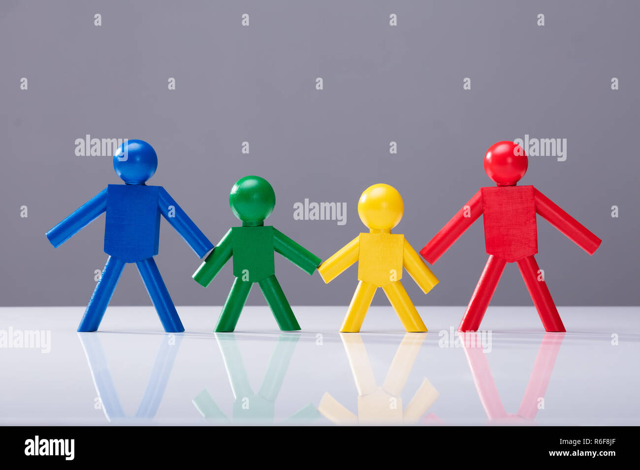 Multi Colored Human Figures Standing In A Row Stock Photo - Alamy