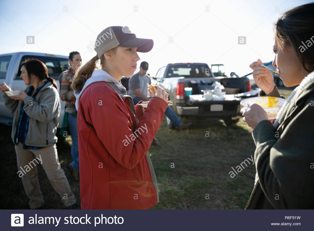 Female farmers eating lunch, taking a break on sunny farm Stock Photo ...