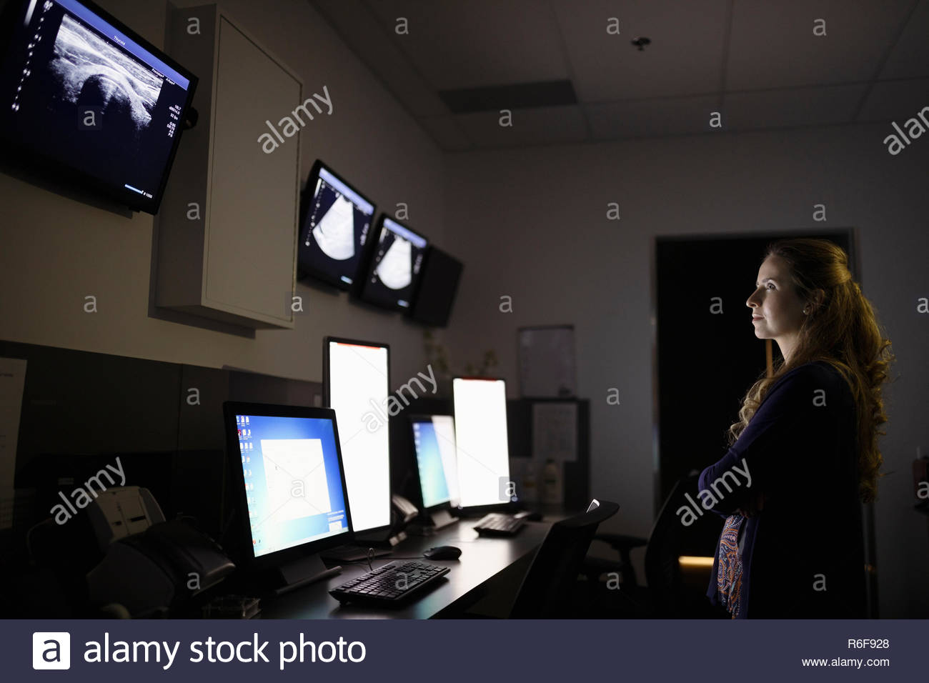 Focused female technician viewing ultrasound x-rays in dark room Stock ...