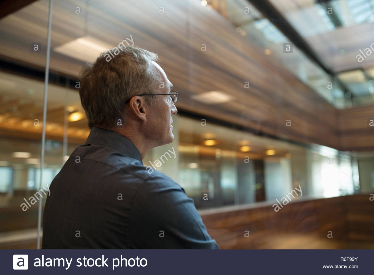 Thoughtful businessman looking out office window Stock Photo - Alamy Thoughtful businessman looking out office window Stock Photo - Alamy