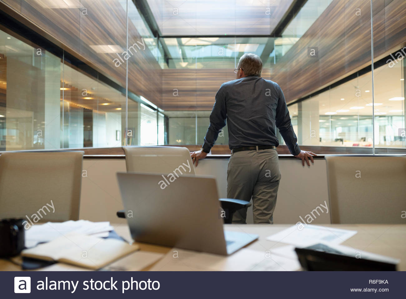 Thoughtful businessman looking out office window Stock Photo - Alamy