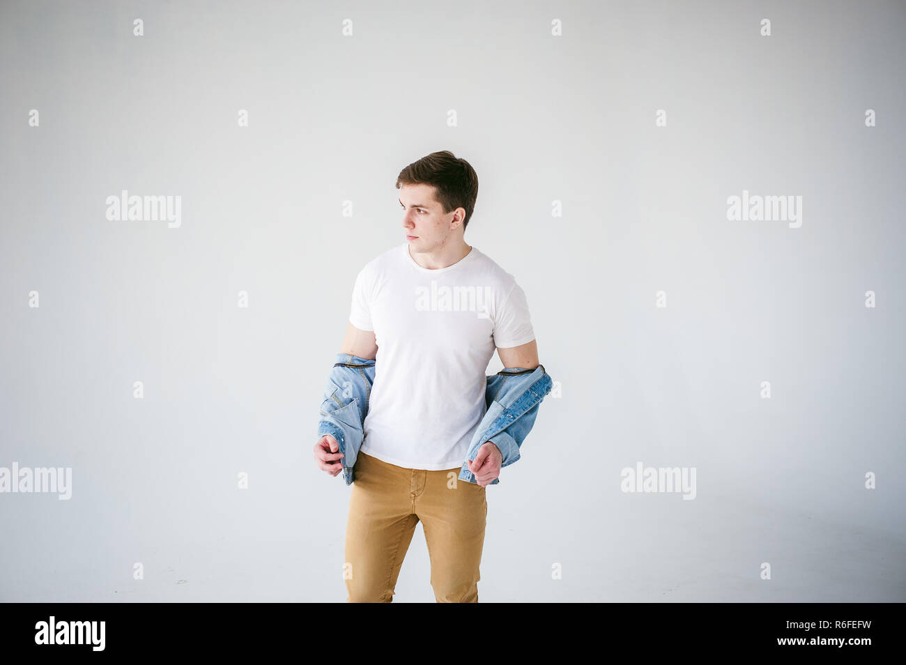 Young handsome man of strong Athlete's body, dressed in Blue jeans ...