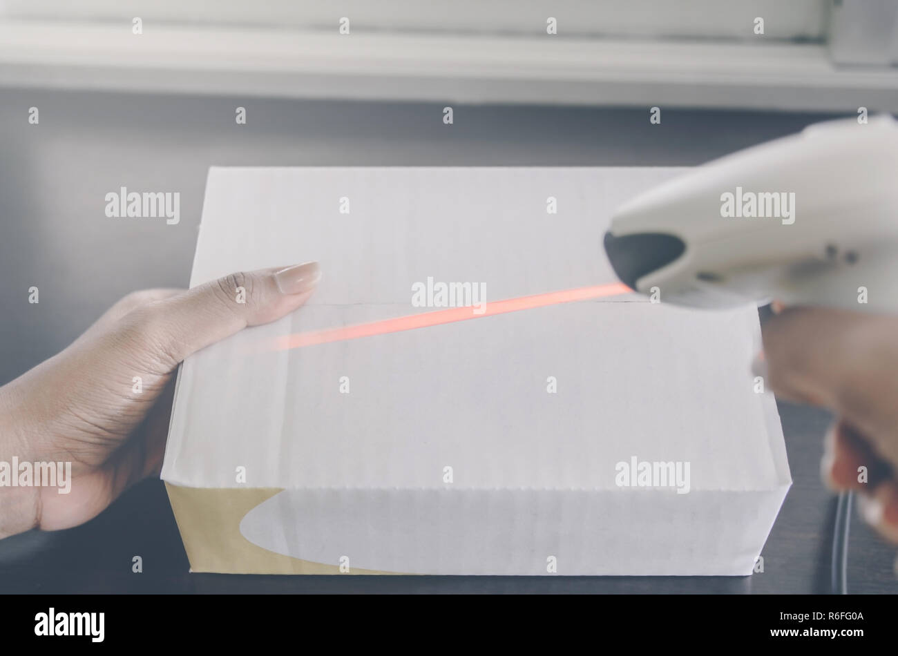 A parcel box and hand holding a package with barcode reader, Delivery ...