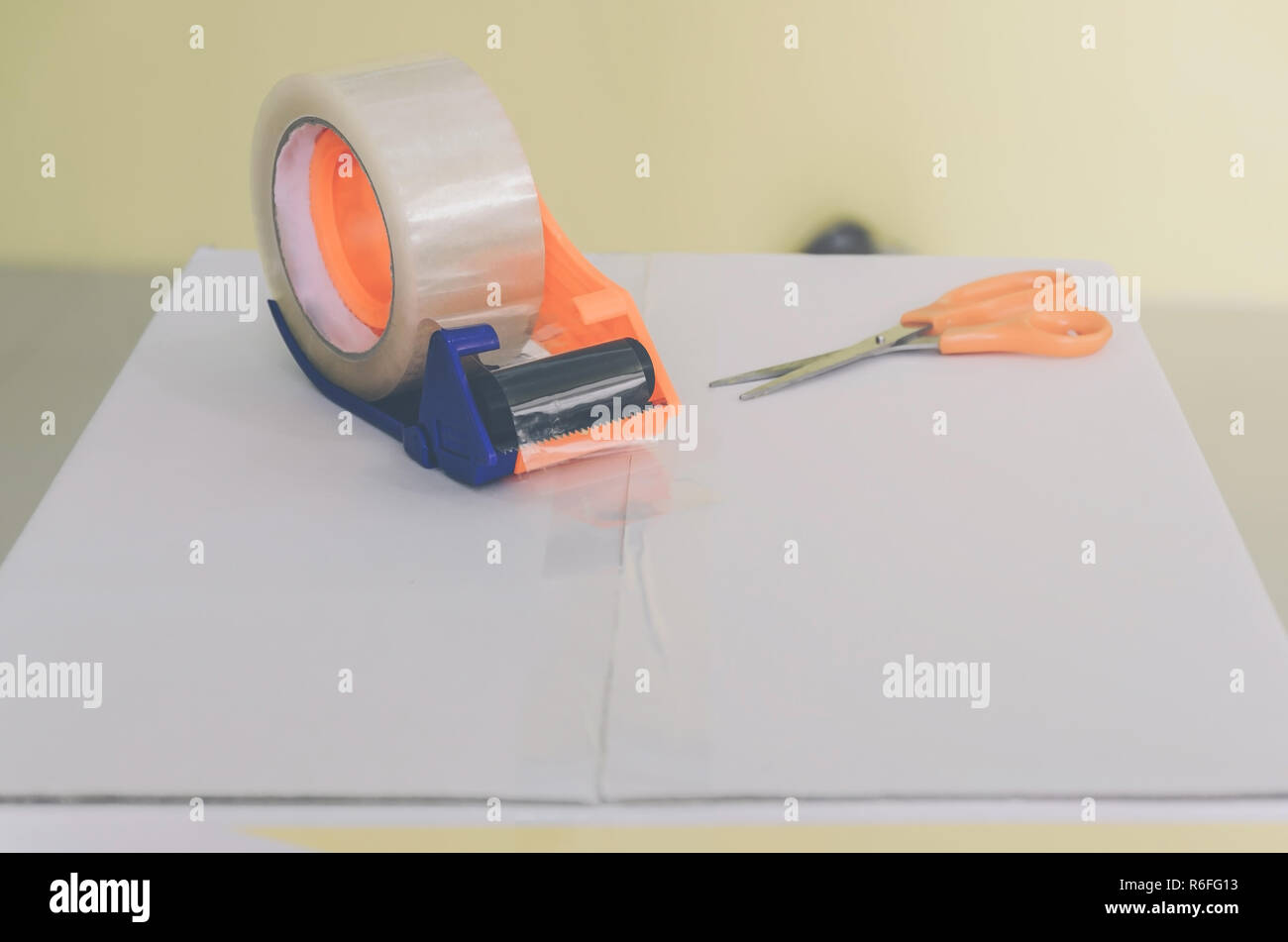 Close - up of parcel box with scissors and scotch tape cutter ...