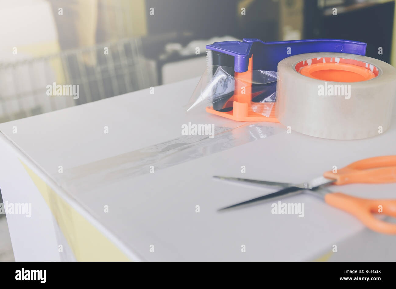 Close - up of parcel box with scissors and scotch tape cutter ...