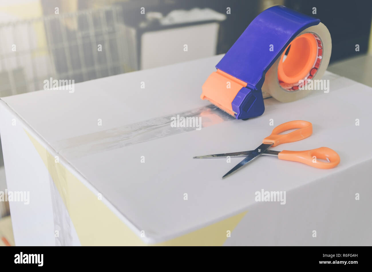 Close - up of parcel box with scissors and scotch tape cutter ...