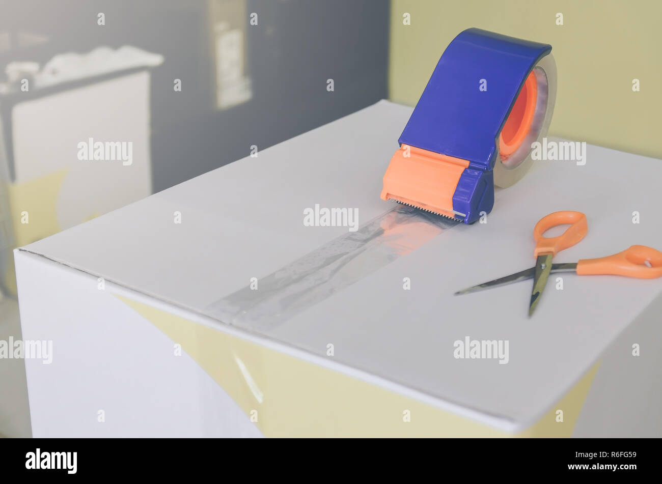 Close - up of parcel box with scissors and scotch tape cutter ...