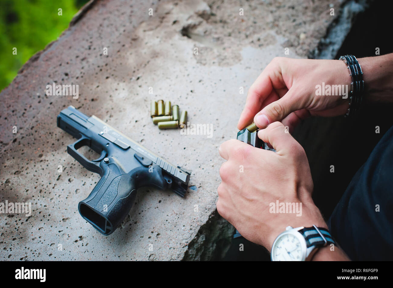 Man charges clip of pistol with bullets. Photo hands of paramilitary ...