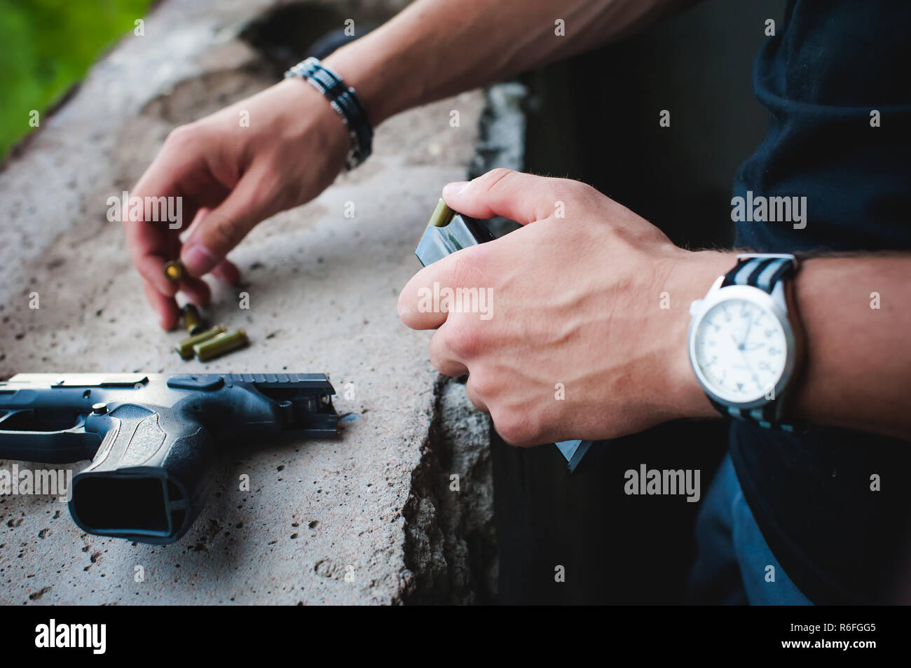 Man charges clip of pistol with bullets. Photo hands of paramilitary ...