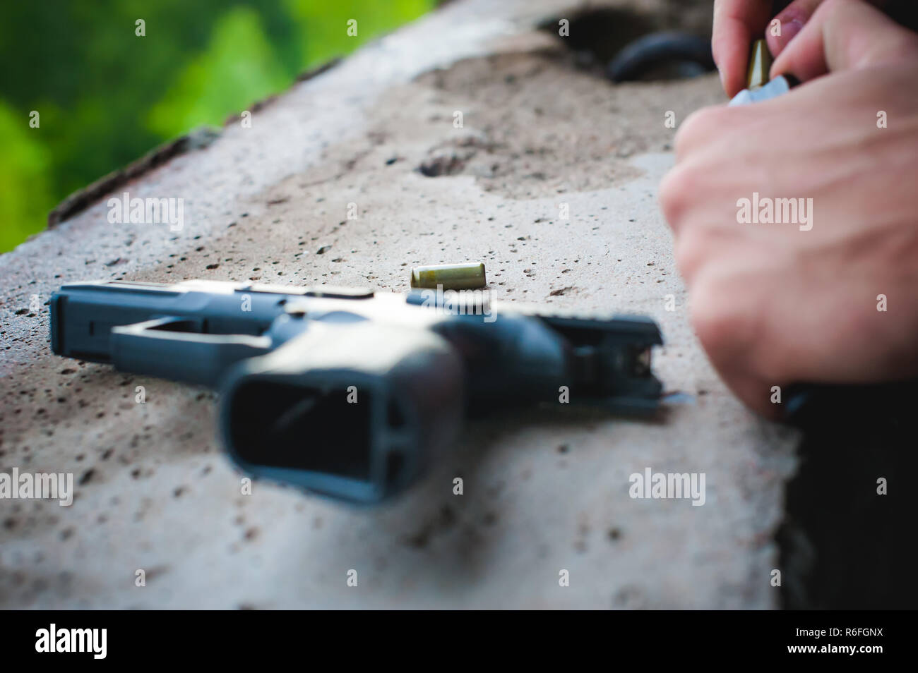 Man charges clip of pistol with bullets. Photo hands of paramilitary ...