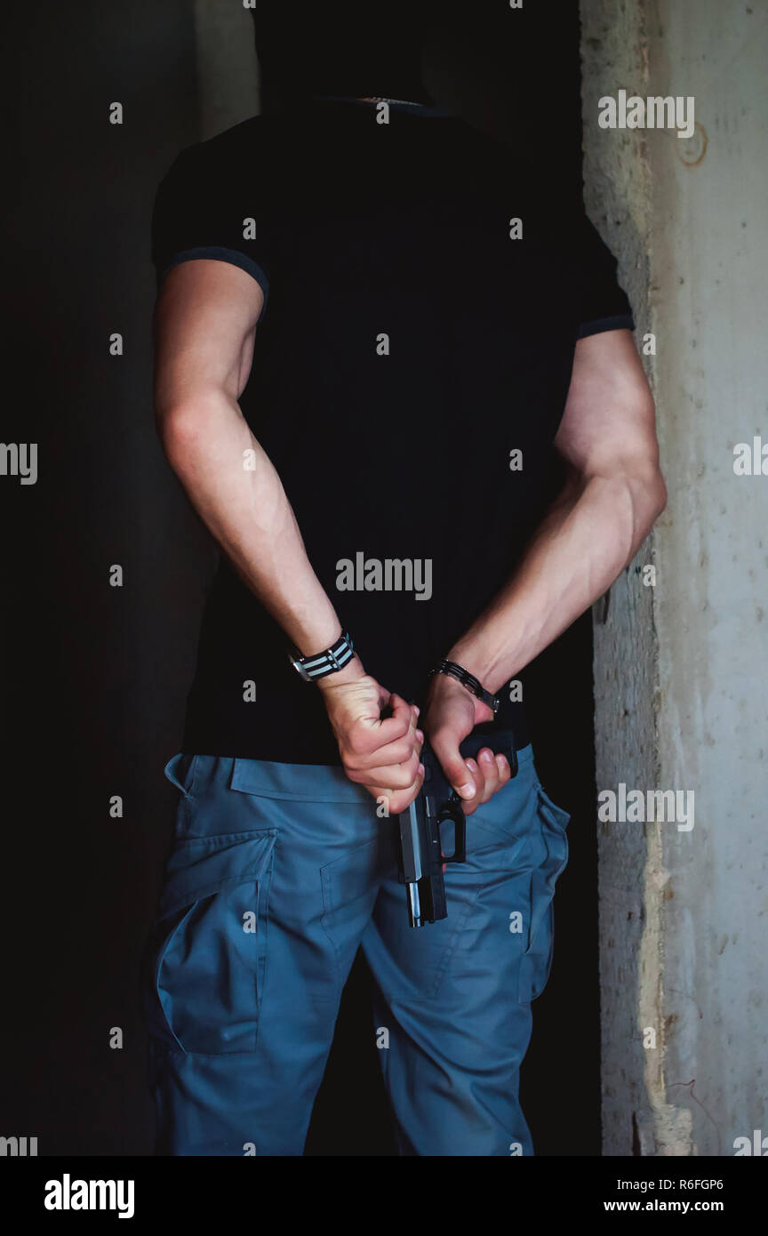 Athletic man, a dangerous gangster, reloads a gun behind his back Stock ...