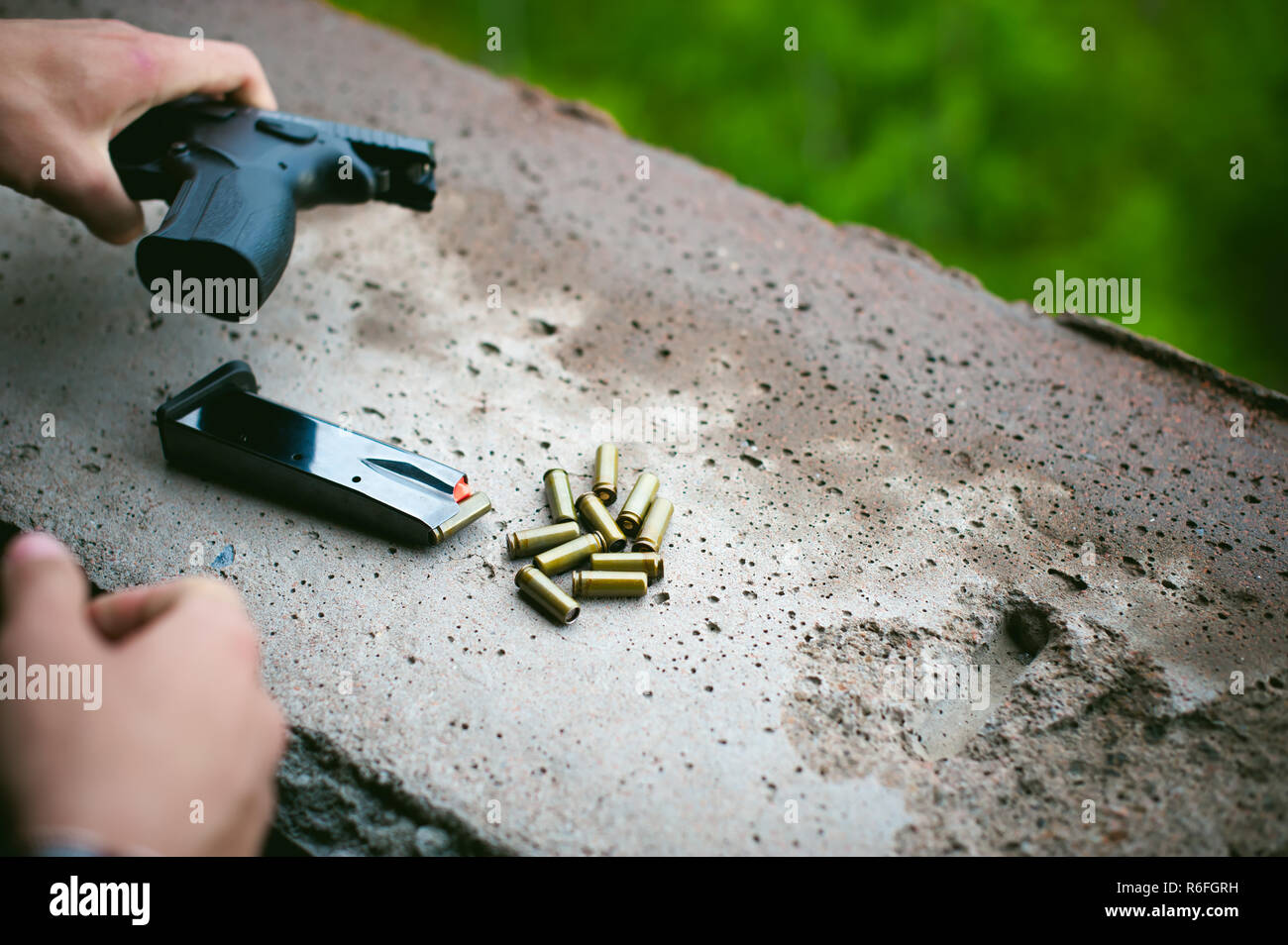 Man charges clip of pistol with bullets. Photo hands of paramilitary ...