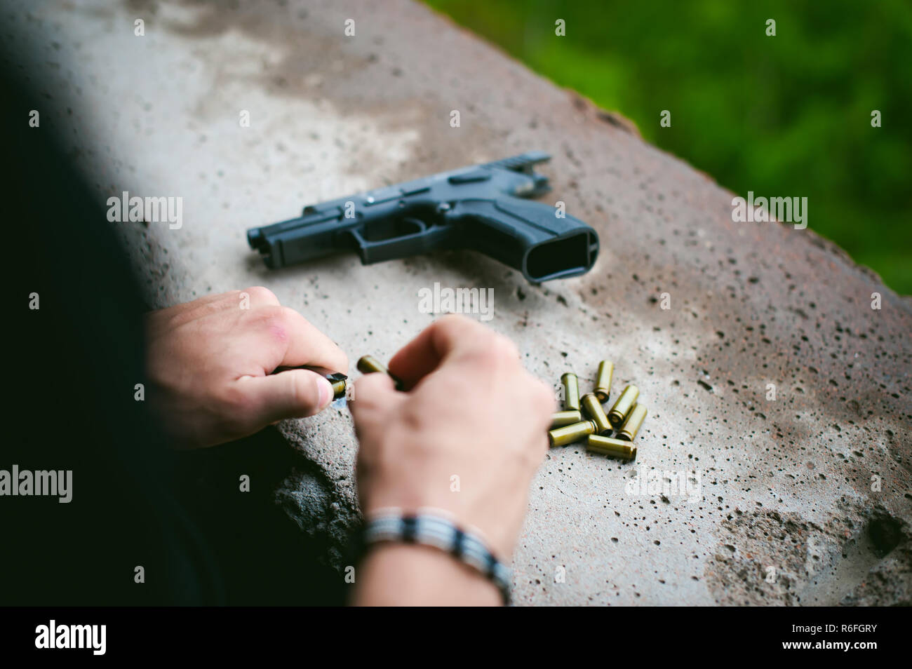 Man charges clip of pistol with bullets. Photo hands of paramilitary ...