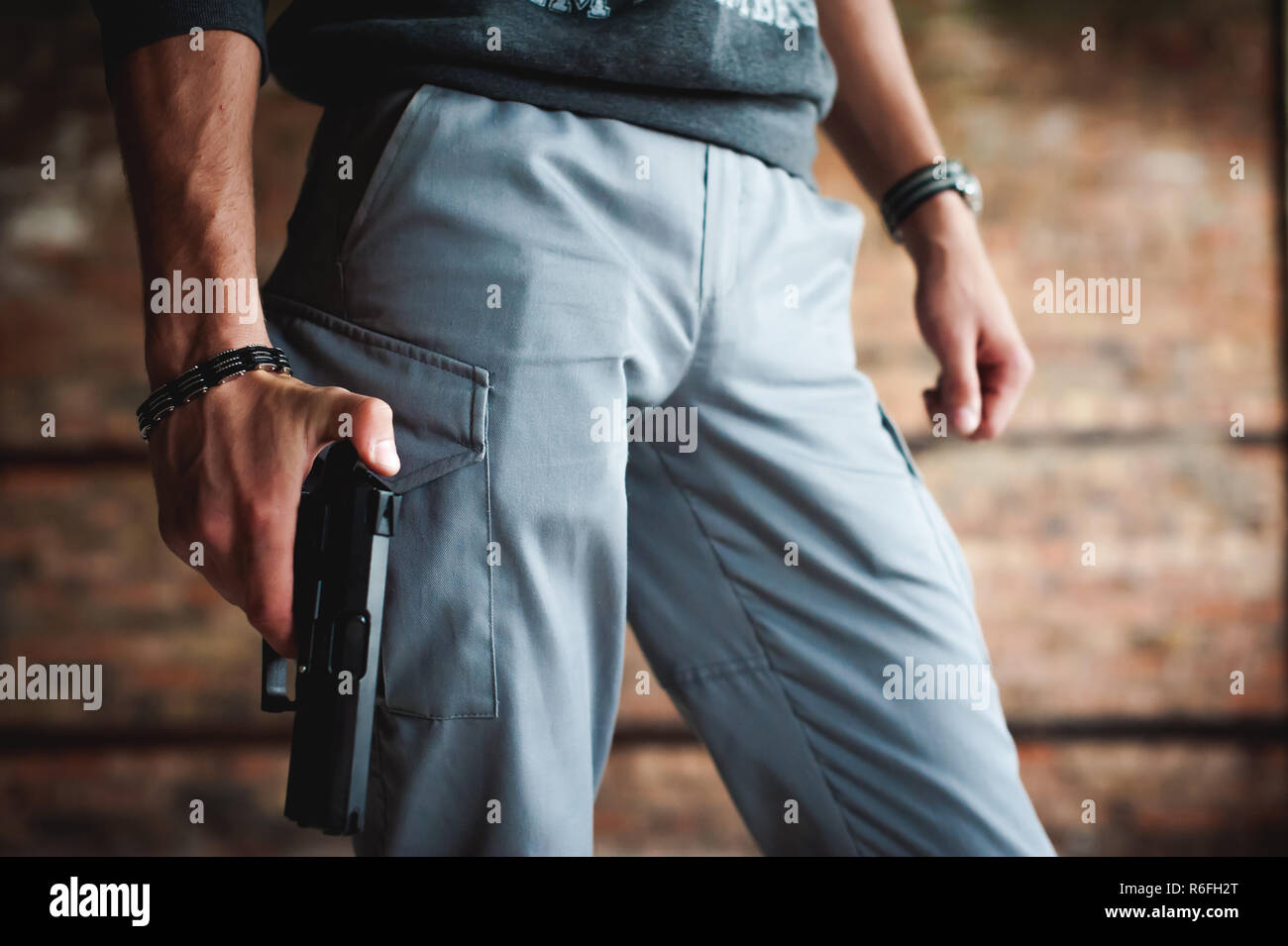 athletic man holding a gun in his hand on the ready Stock Photo - Alamy